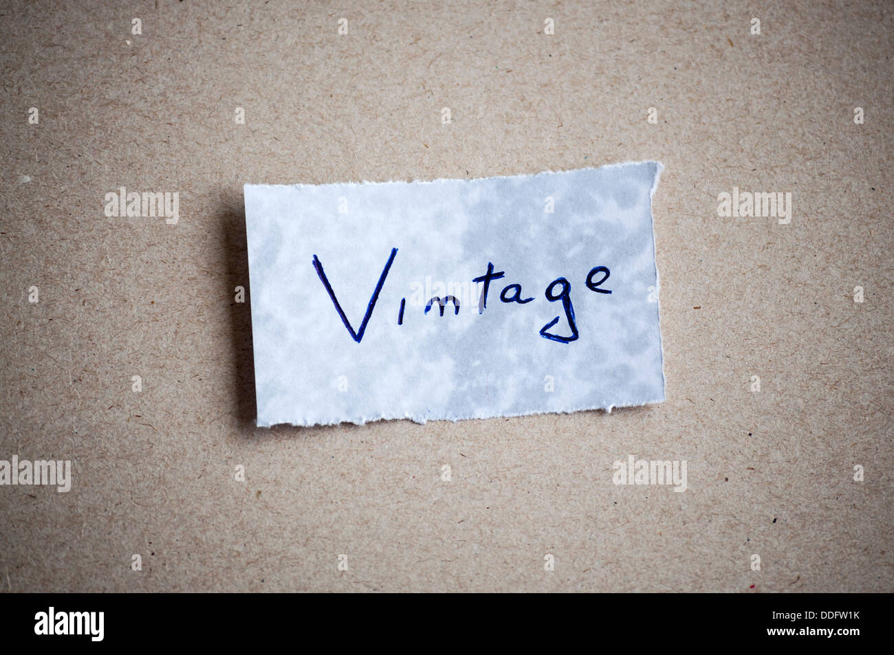 Vintage message,written on piece of paper, on cardboard background ...