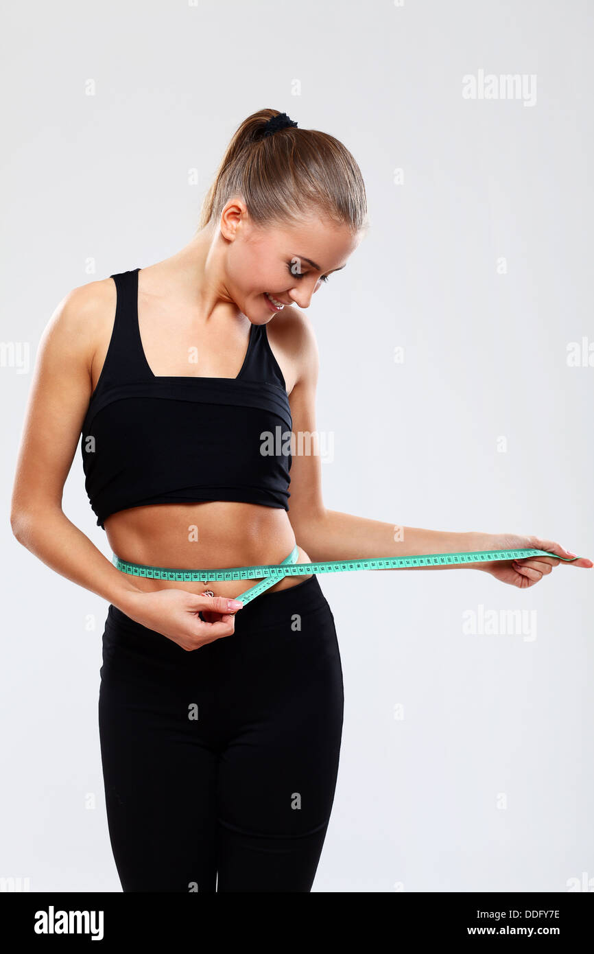 Happy girl measuring her waist with a ruler Stock Photo - Alamy