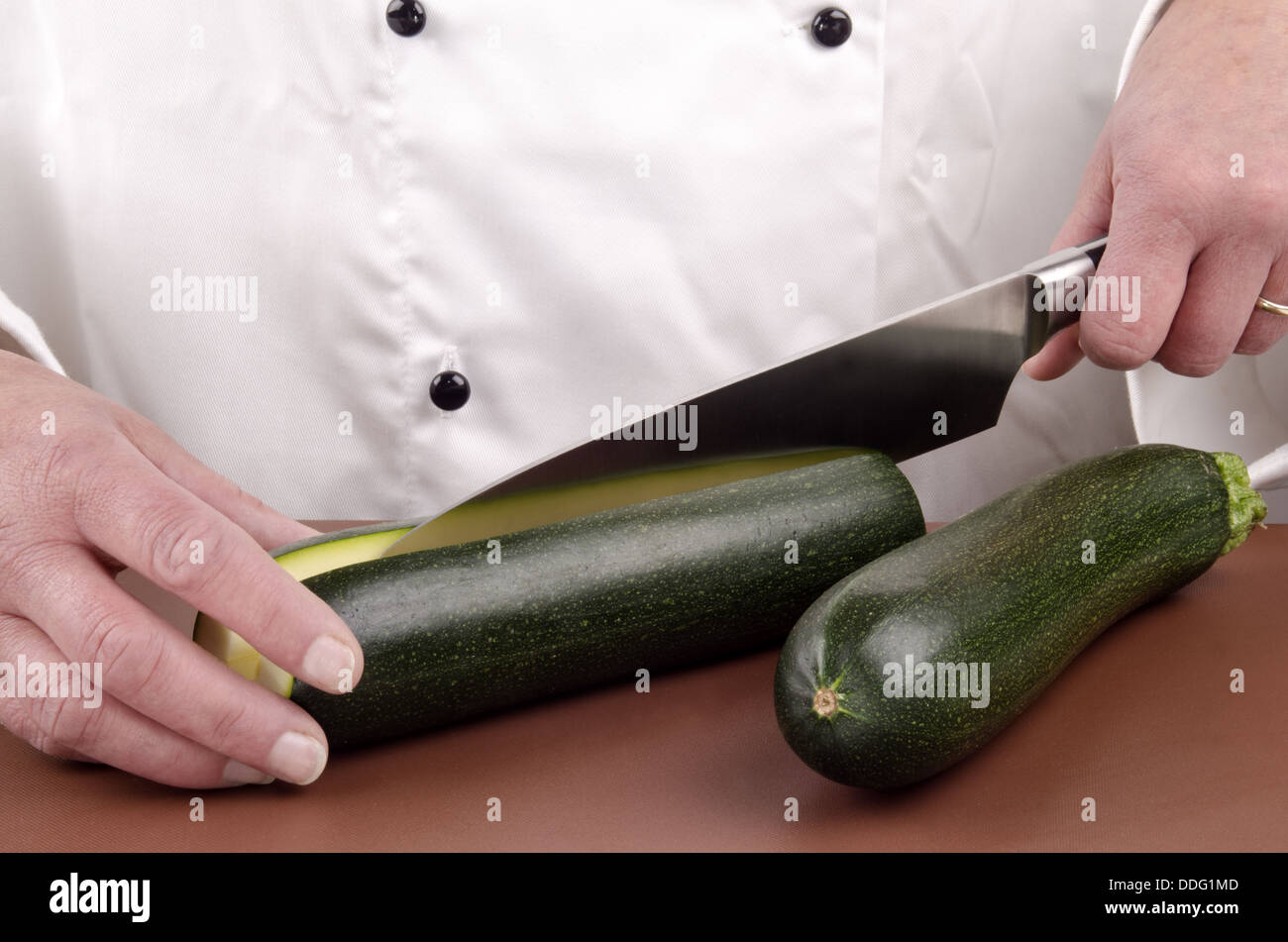 female chef cut one zucchini with a kitchen knife Stock Photo - Alamy
