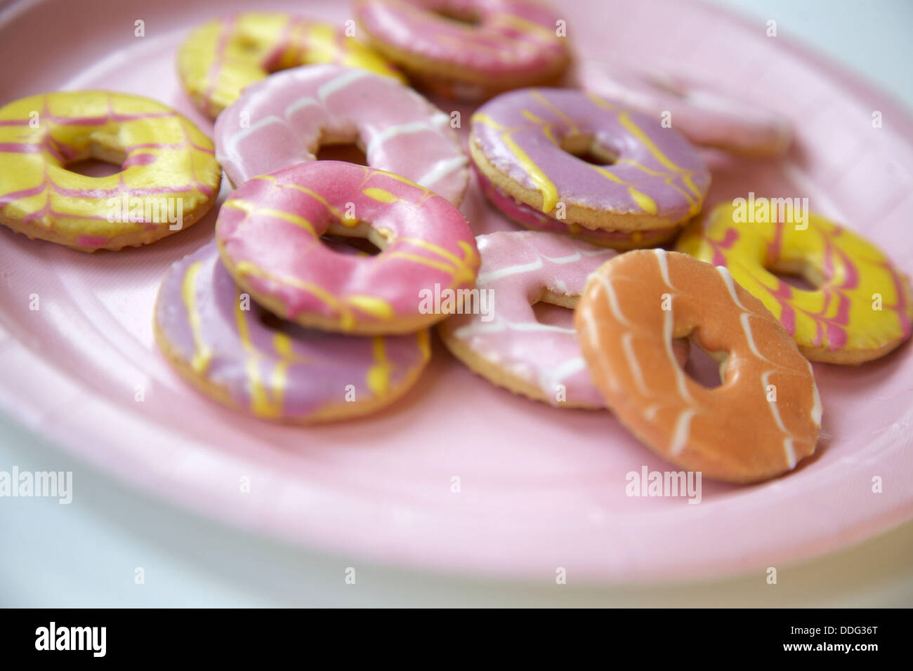 Selection of coloured iced biscuits on a paper plate Stock Photo - Alamy