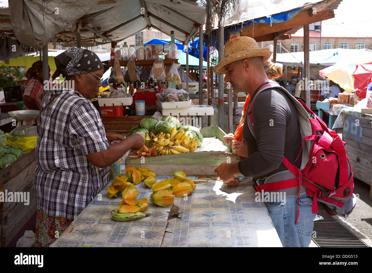 Tourist purchasing Star fruit at fruit and vegetable market St. George ...