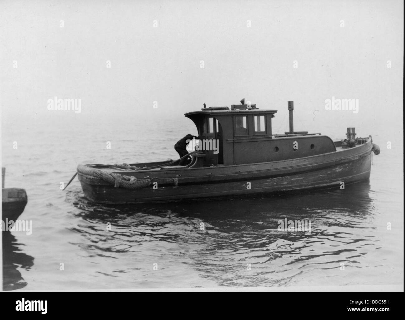 This photograph features a tugboat, a type of powerful boat used to tow ...