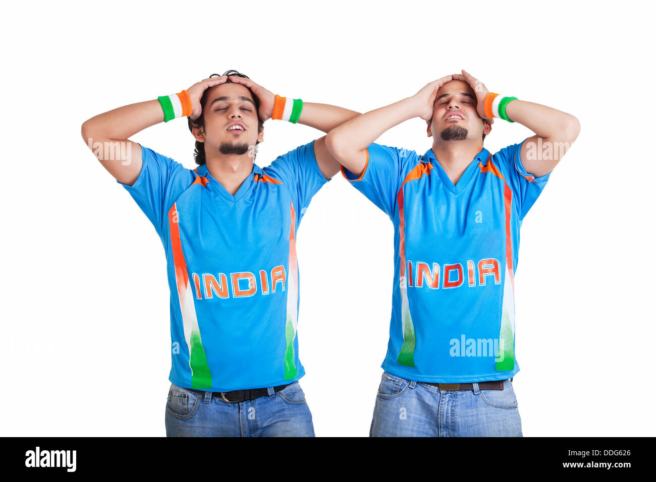 Disappointed young male friends in jerseys standing over white ...