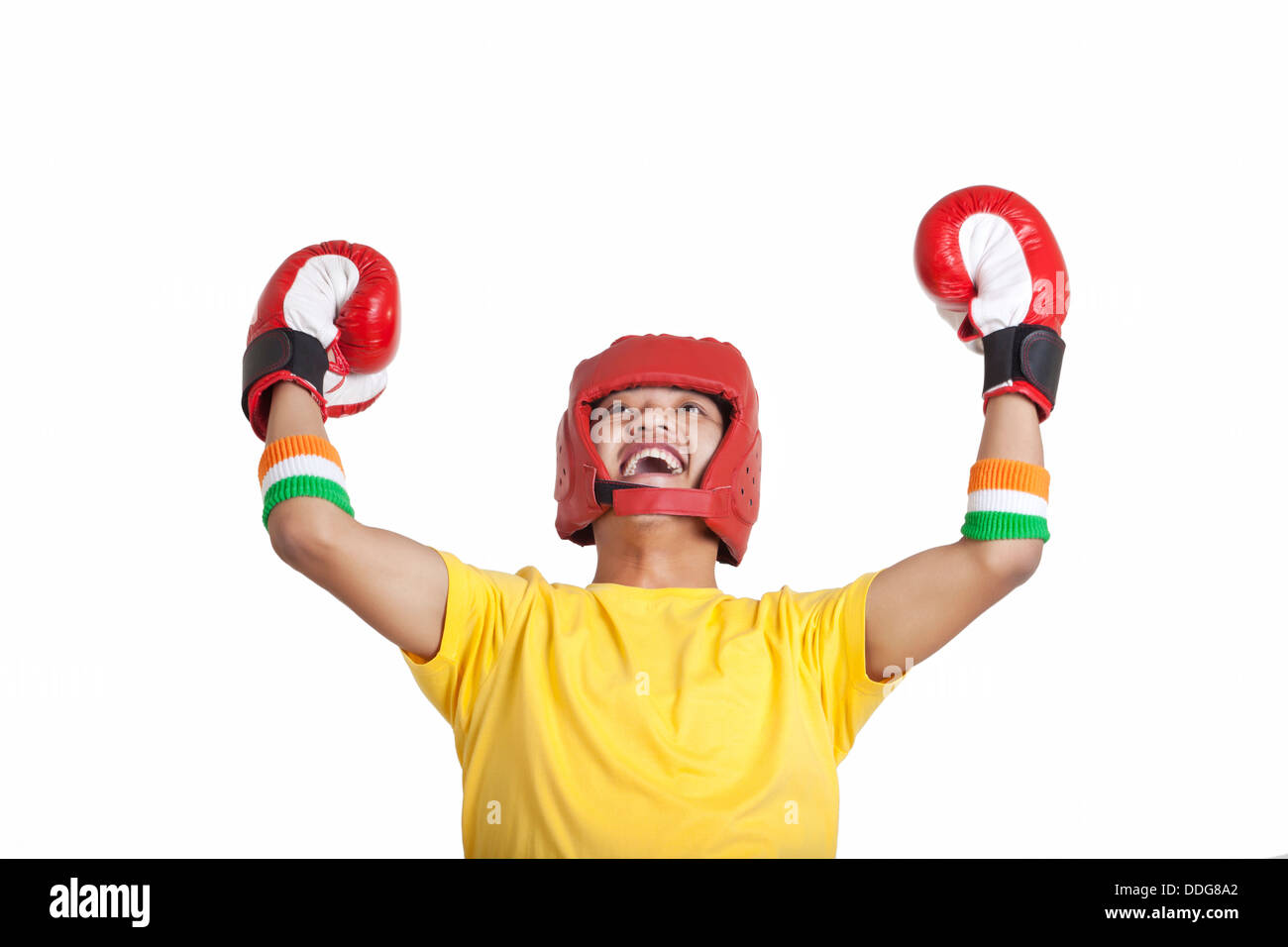 Cheerful young male boxer looking up with hands raised over white ...