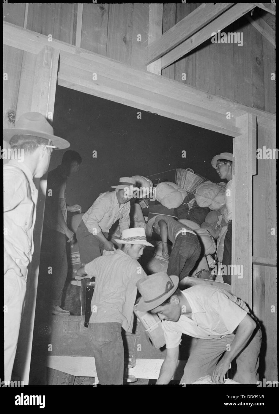 In Poston, Arizona, evacuees load baggage upon arrival at the ...
