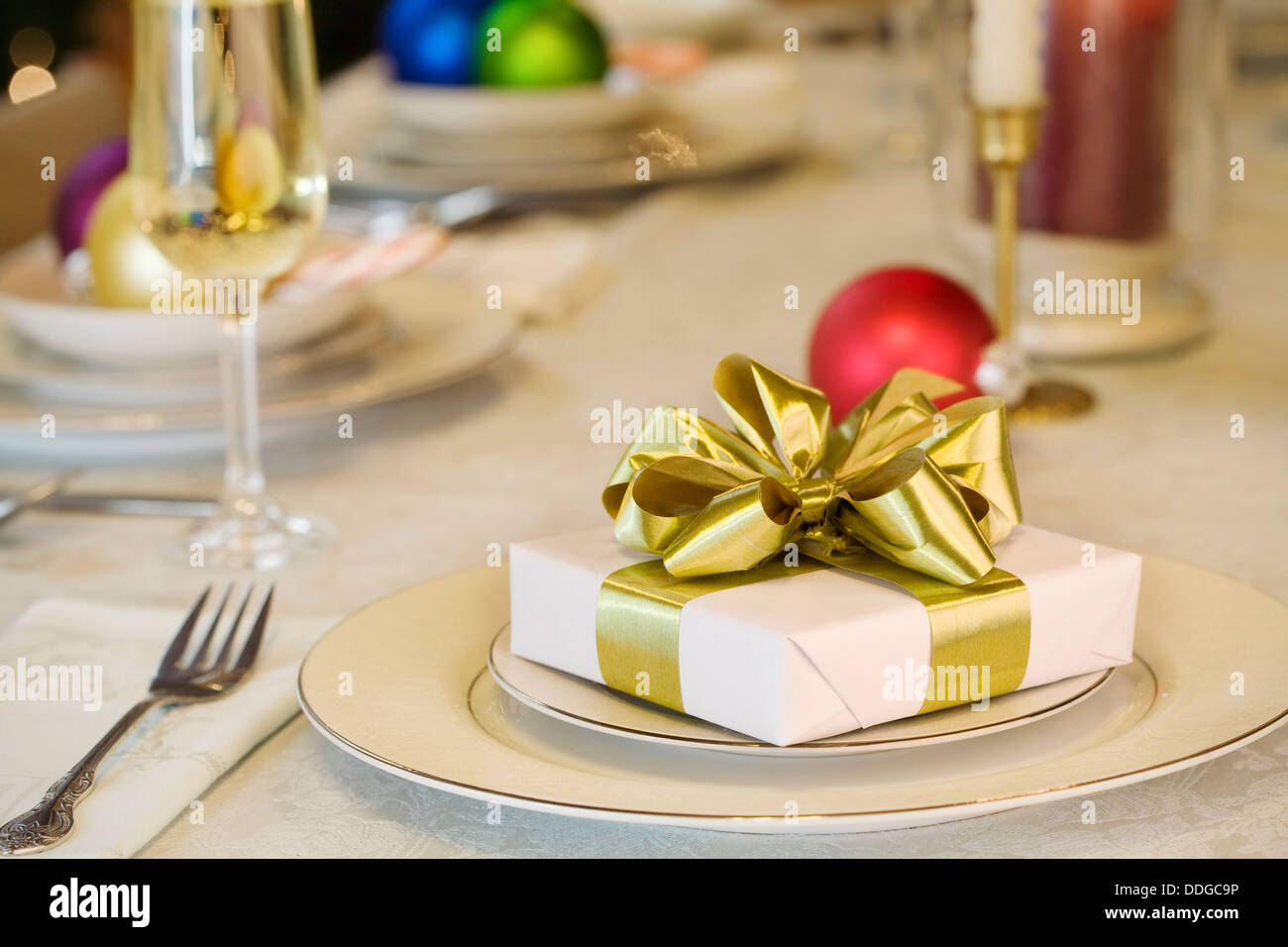 Gold ribbon gift on dining table Stock Photo - Alamy