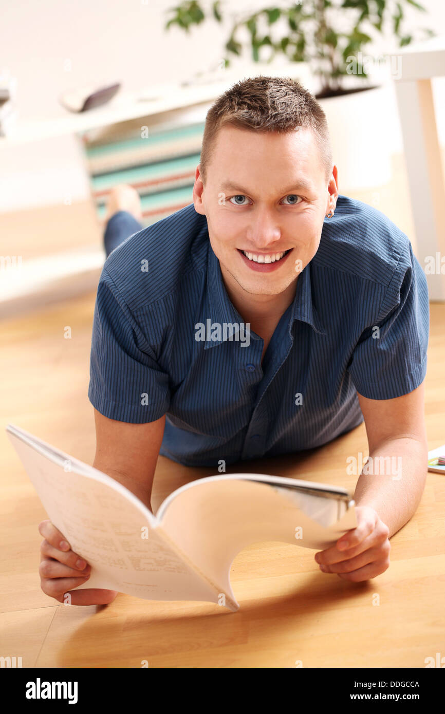 Young man reading magazine at home Stock Photo - Alamy