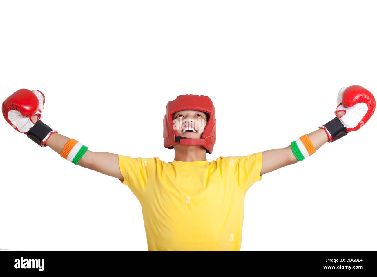 Happy young male boxer looking up with arms out over white background ...