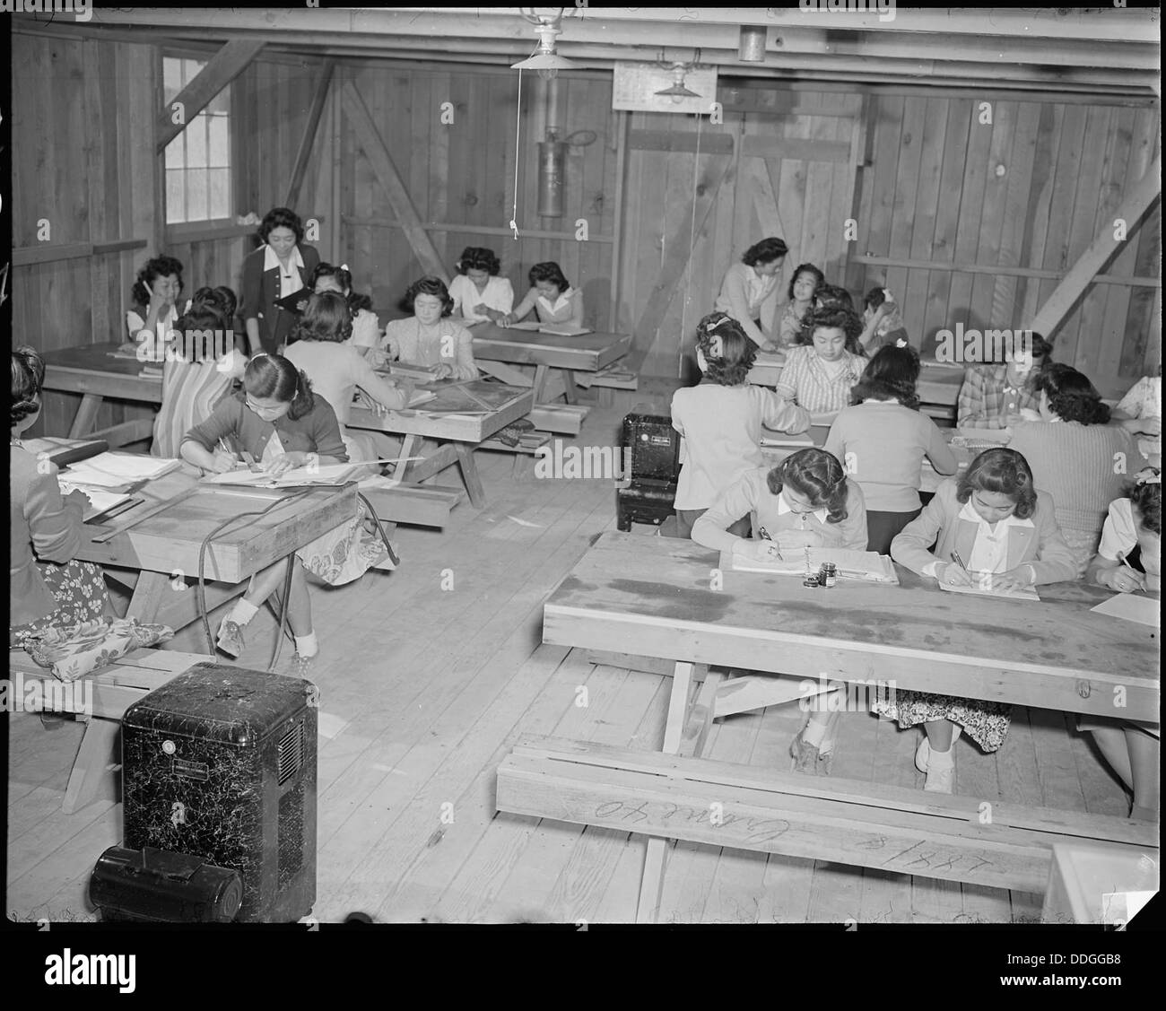 This photograph captures a sewing school in Poston, Arizona, where ...