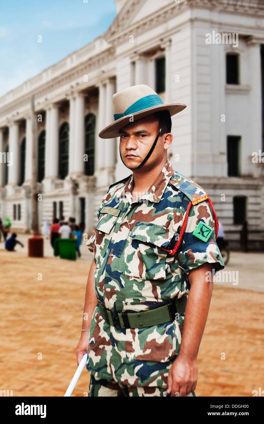 Army soldier standing on the road with a building in the background ...