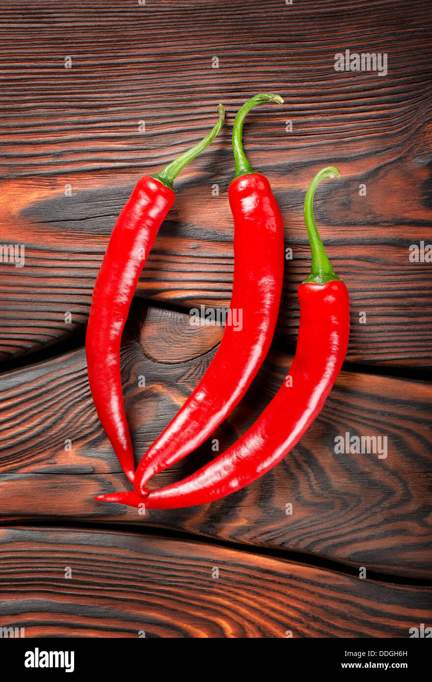 Three red chili peppers Stock Photo - Alamy