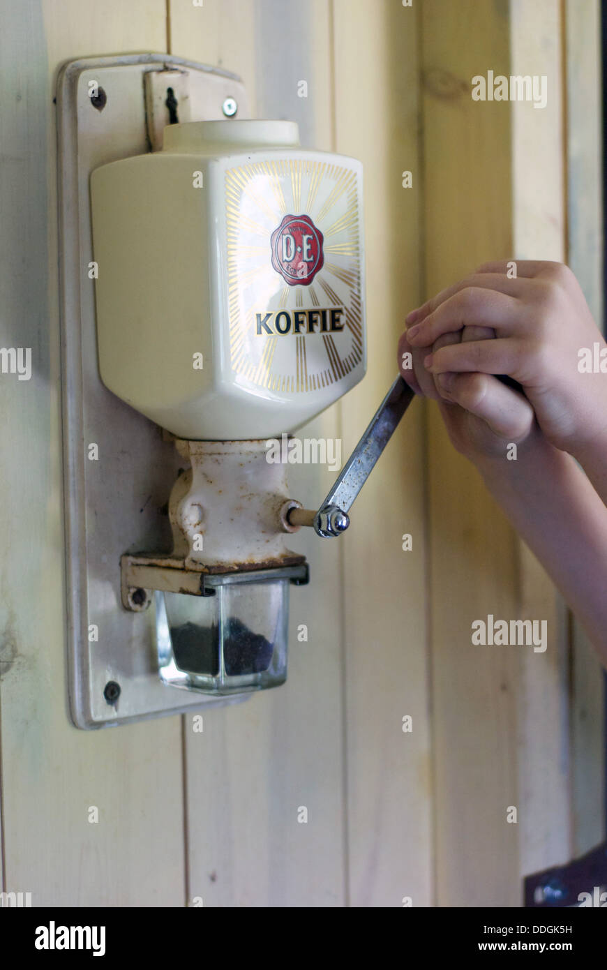 Old fashioned coffee grinder being used by a child Stock Photo - Alamy