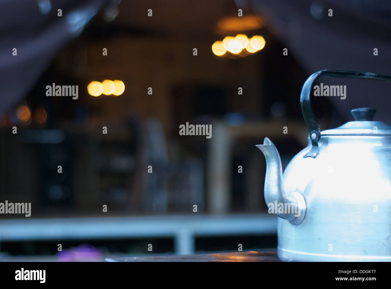 Close up of kettle outside glamping tent lit by candlelight Stock Photo ...