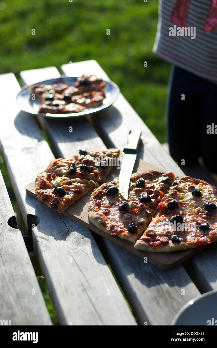 Freshly cooked pizzas just out of the oven on an outdoor picnic table ...