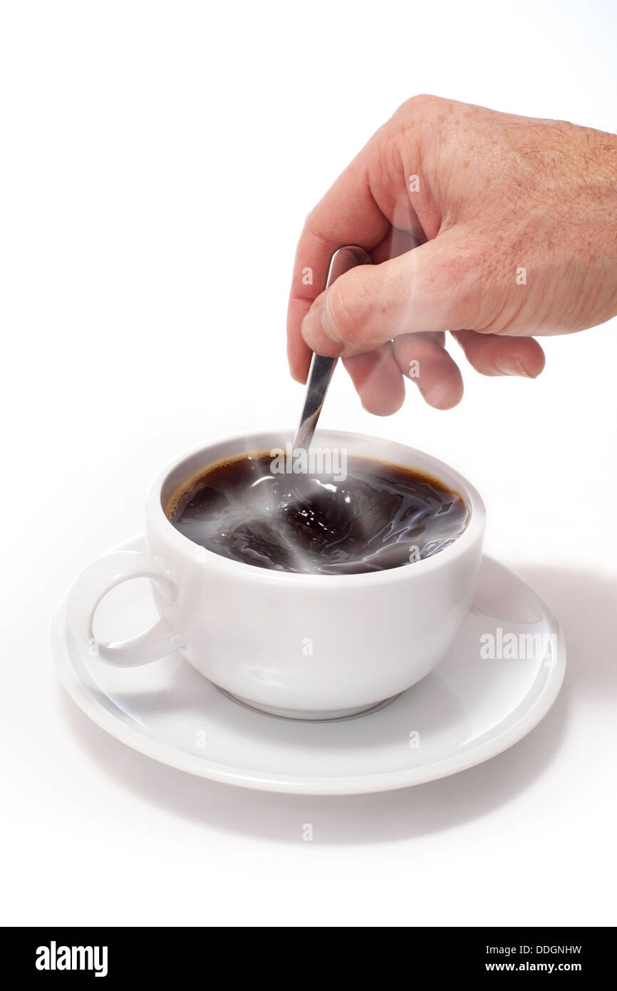 A hand stirring a white Cup of black Coffee on a white isolated ...