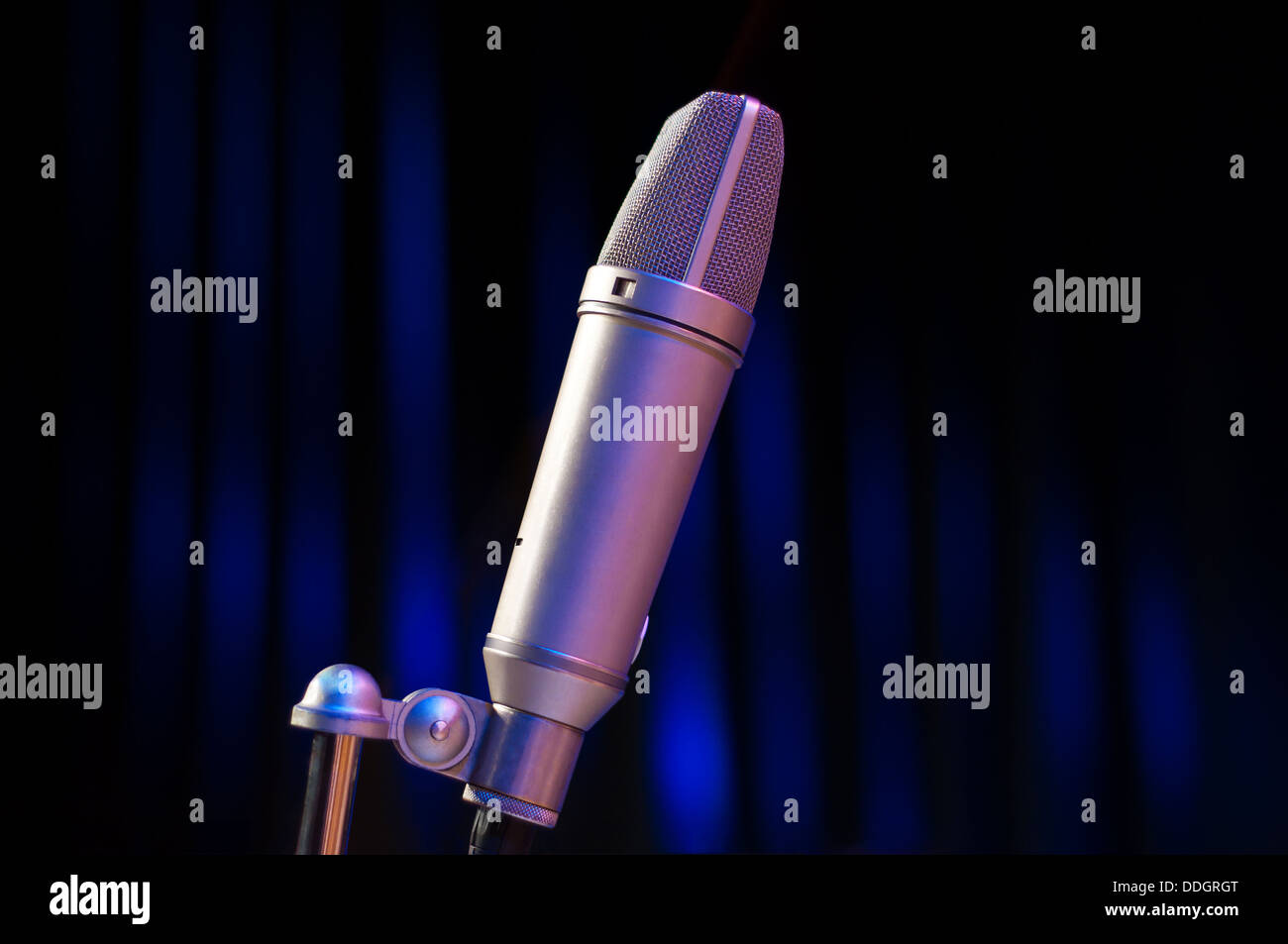 microphone on stage with blue and black background Stock Photo - Alamy