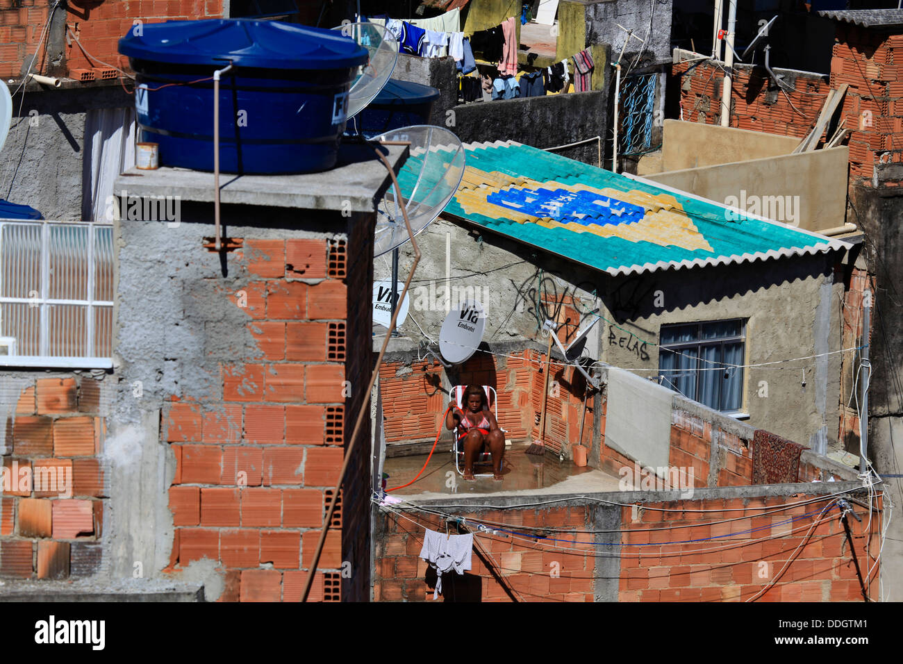 Woman takes sun at her house´ slab-cover in Favela Santa Marta, Rio de ...