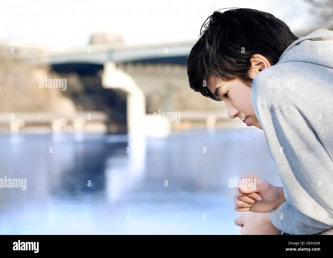 Teen boy sadly looking out over river, thinking Stock Photo - Alamy
