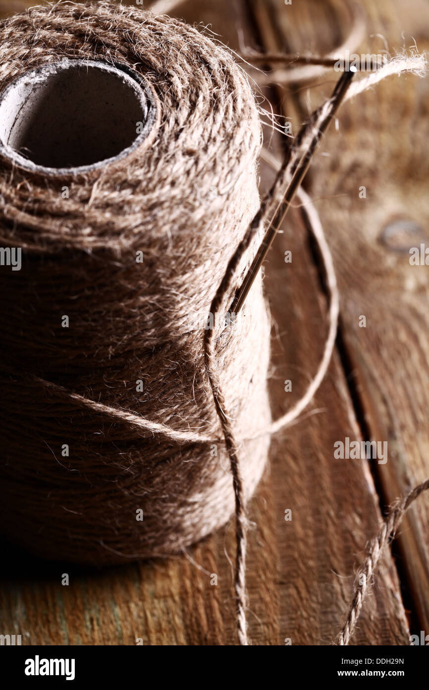 Spool of thread and needle over wooden surface Stock Photo - Alamy