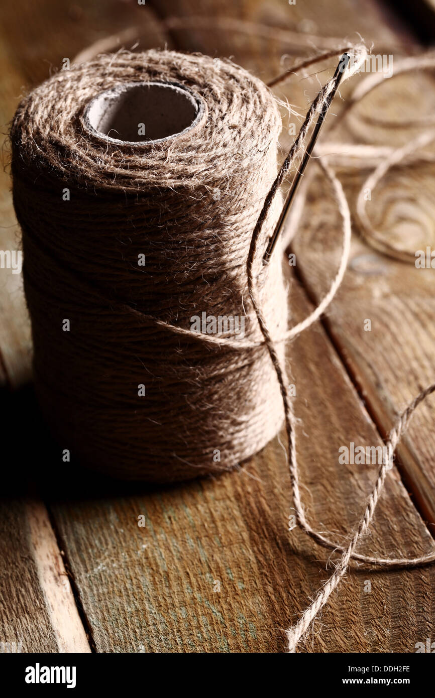 Spool of thread and needle over wooden surface Stock Photo - Alamy
