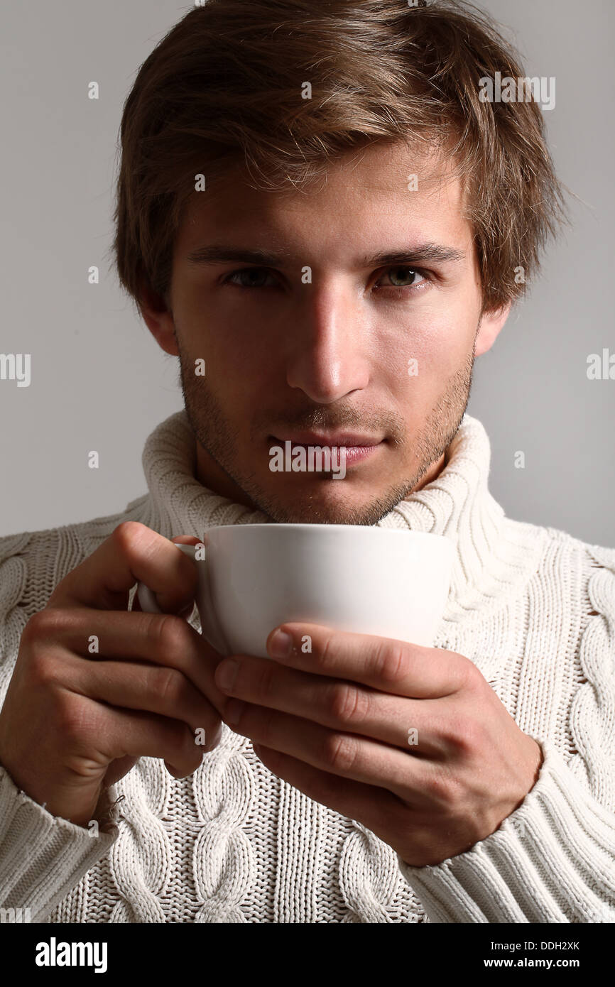 Handsome man in sweater drinking tea Stock Photo - Alamy