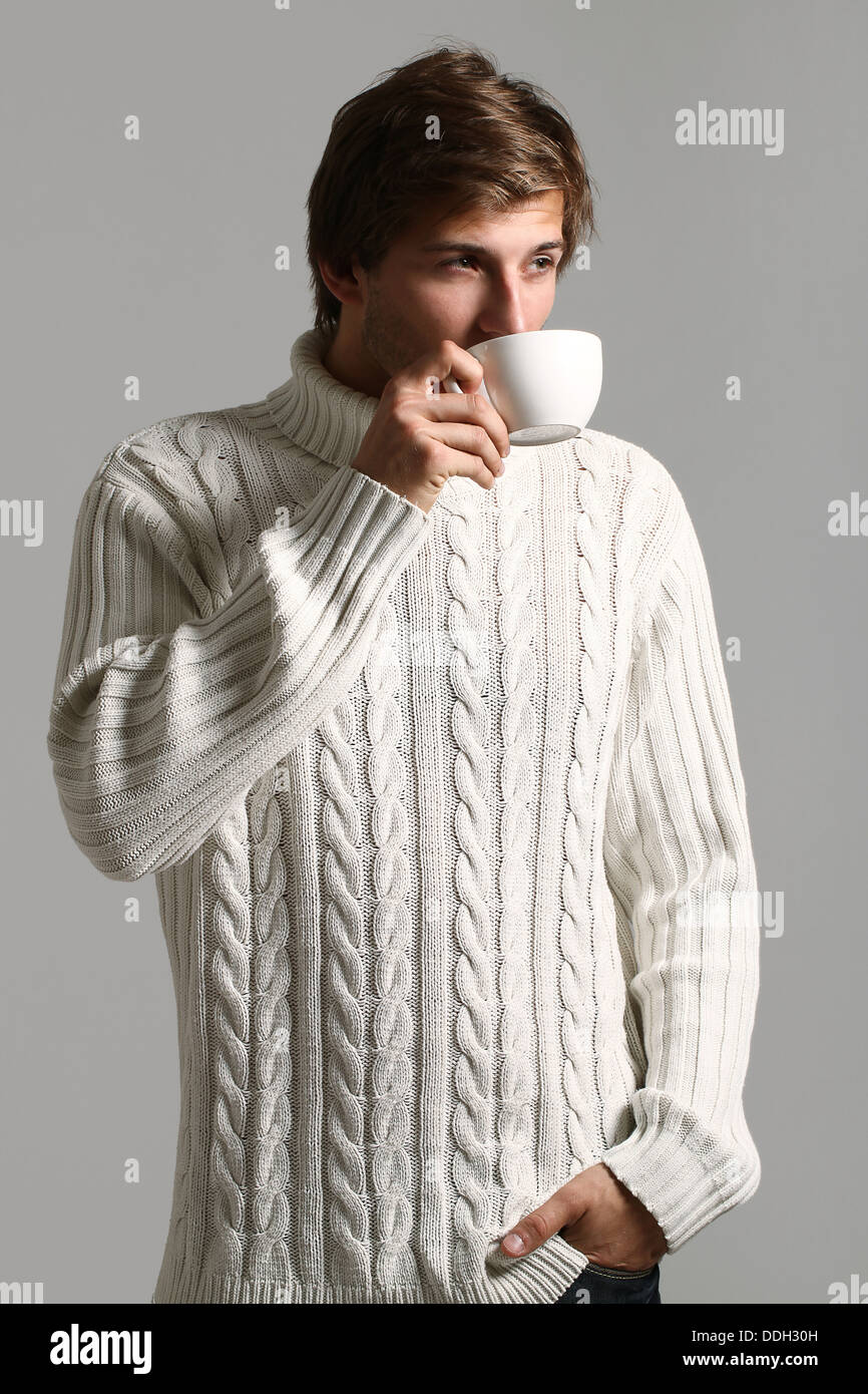 Handsome man in sweater drinking tea Stock Photo - Alamy
