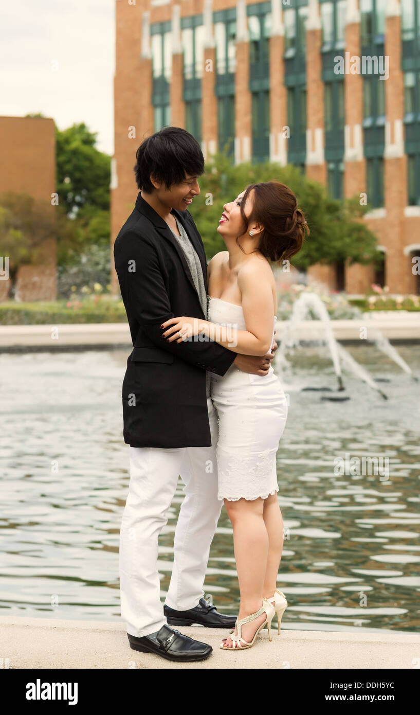 Vertical Photo Of Young Adult Couple Holding Each Other While Standing