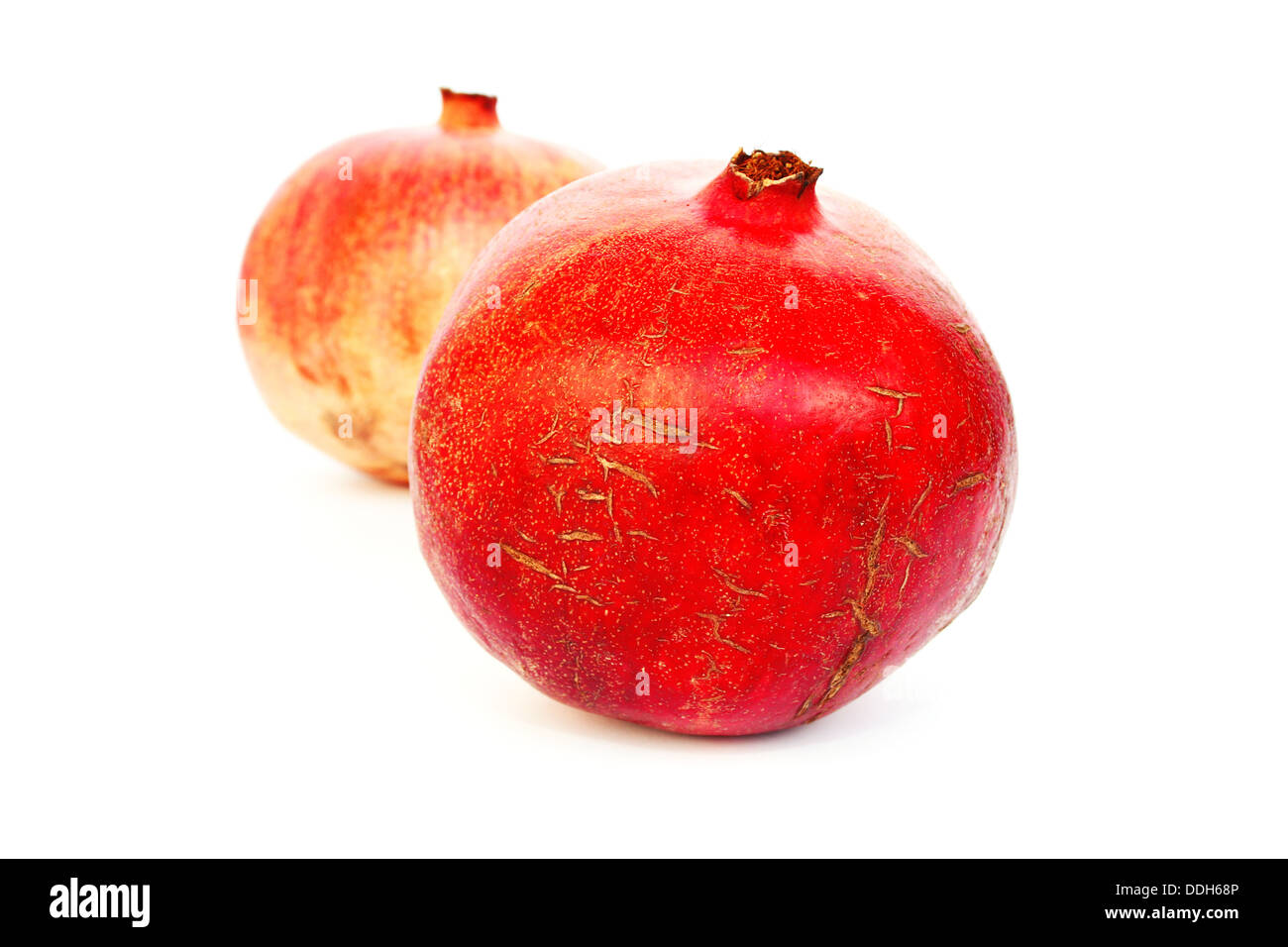 Two pomegranates isolated on white background Stock Photo - Alamy