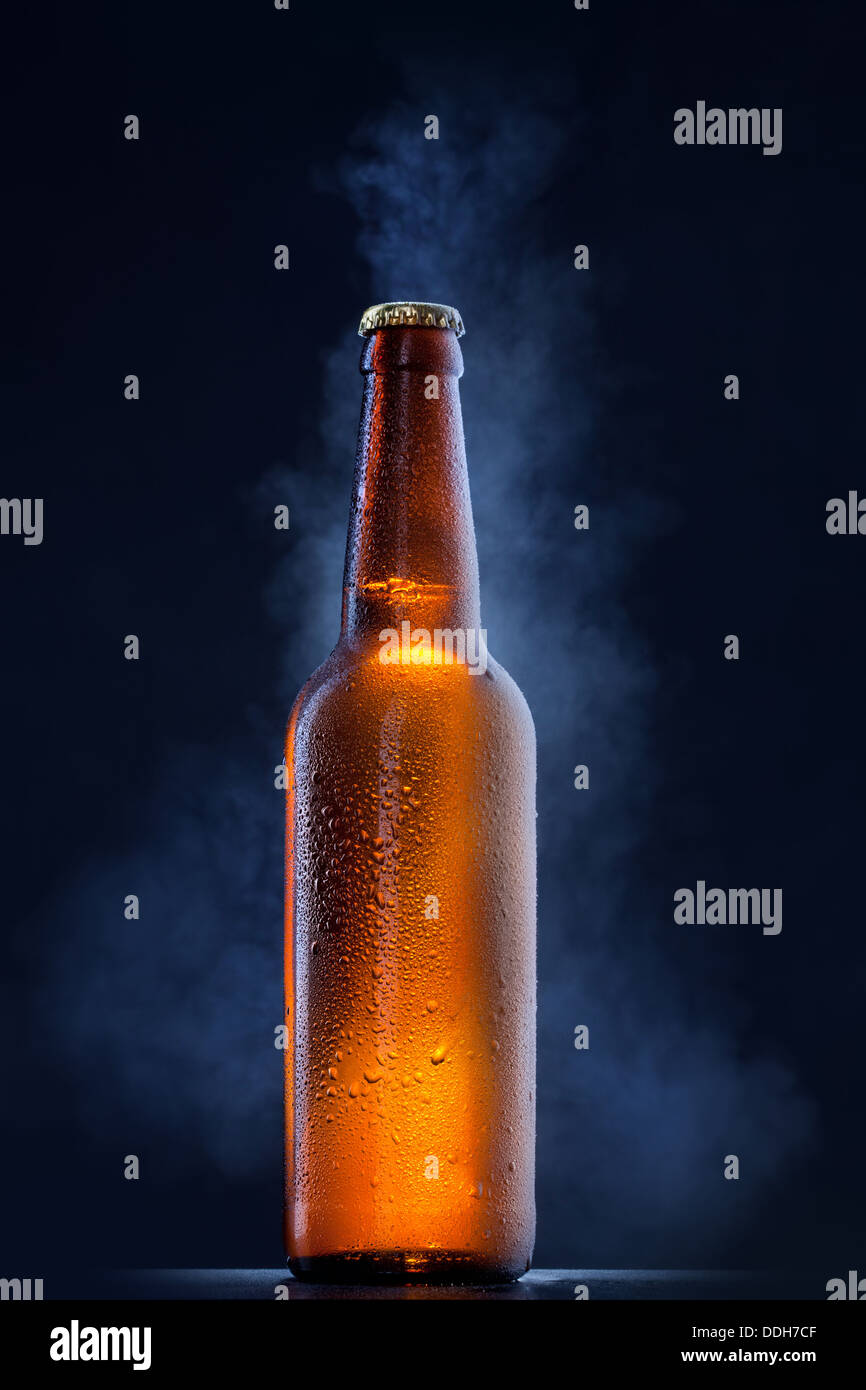 Cold beer bottle with drops, frost and vapour on black Stock Photo - Alamy