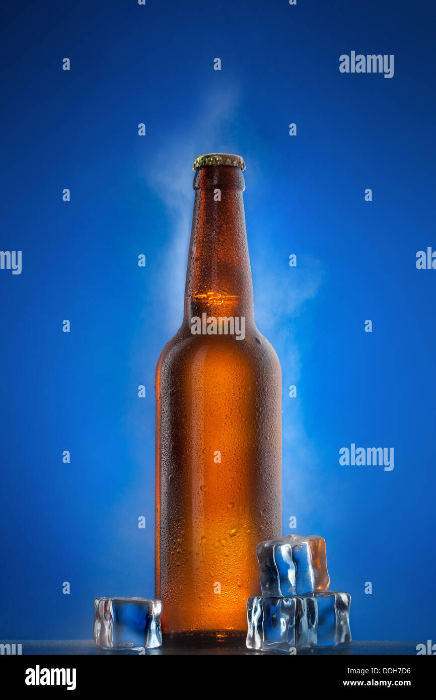 Cold beer bottle with drops, frost and vapour on blue Stock Photo - Alamy