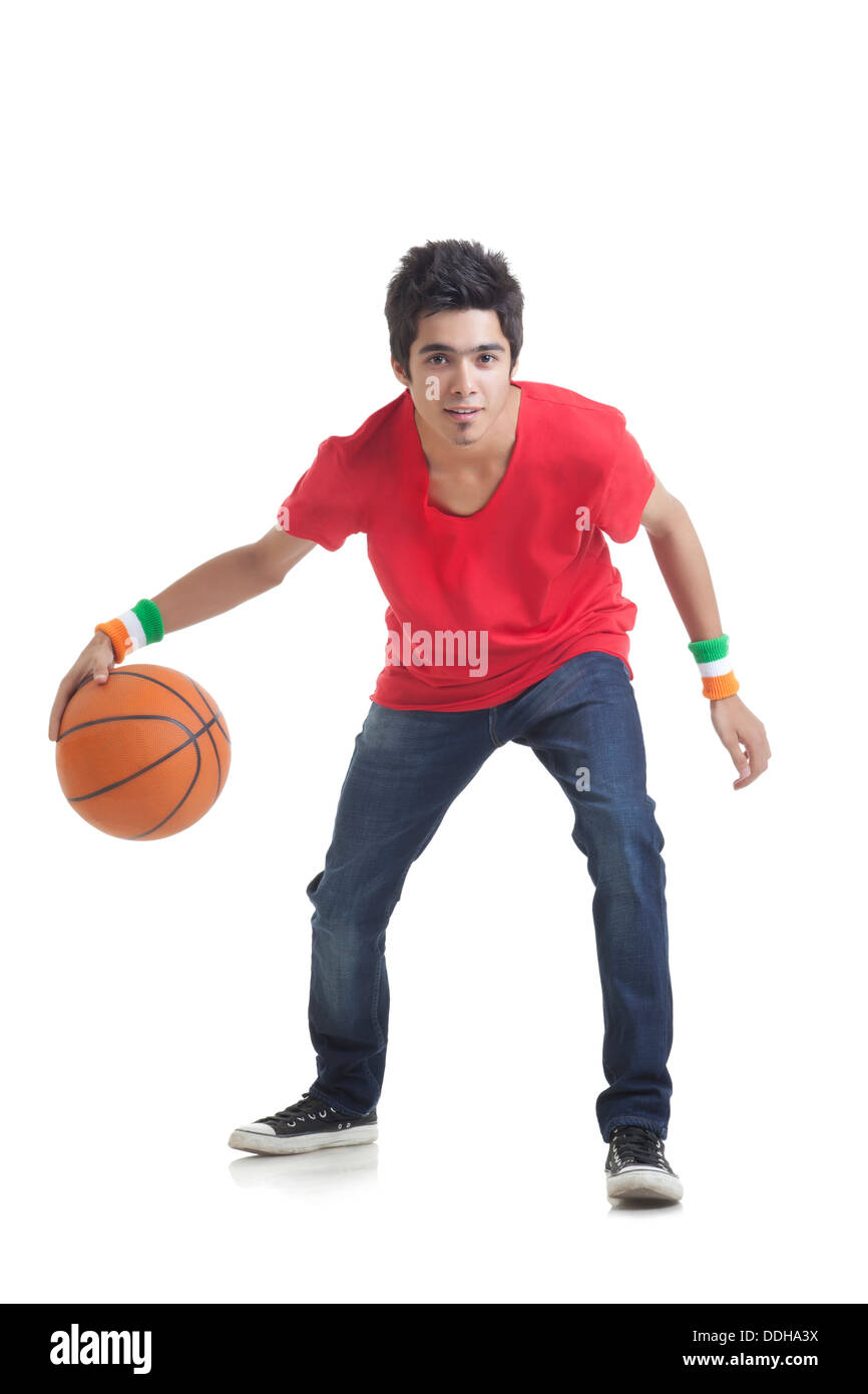 Full length portrait of young boy playing basketball over white ...
