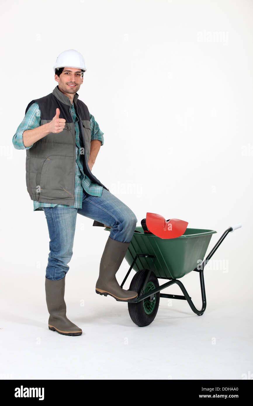 Man stood with wheelbarrow giving thumbs-up Stock Photo - Alamy