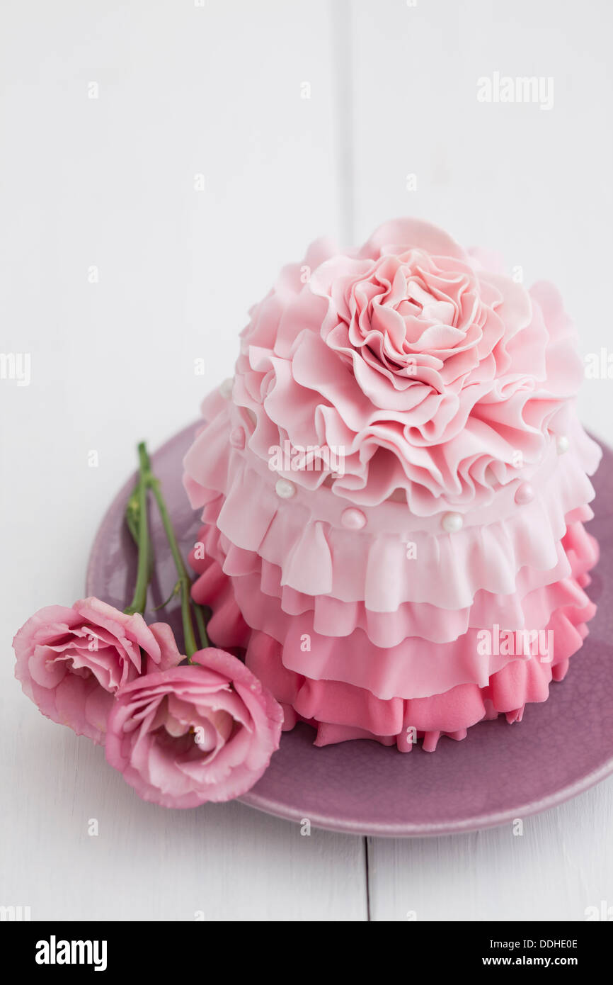 Pink mini cake with pink roses on plate, close up Stock Photo - Alamy