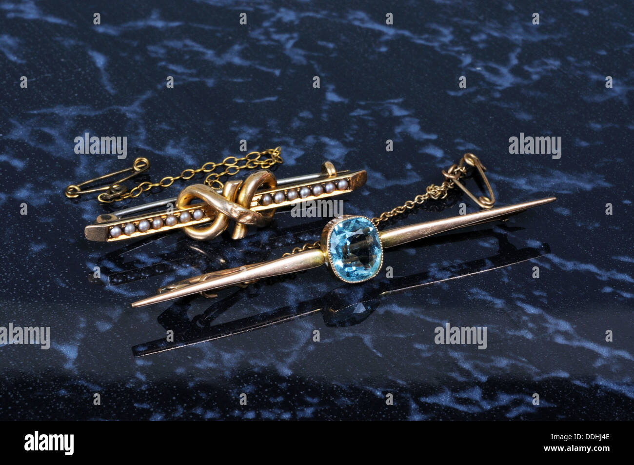 Two antique gold scarf pins against a dark background Stock Photo - Alamy