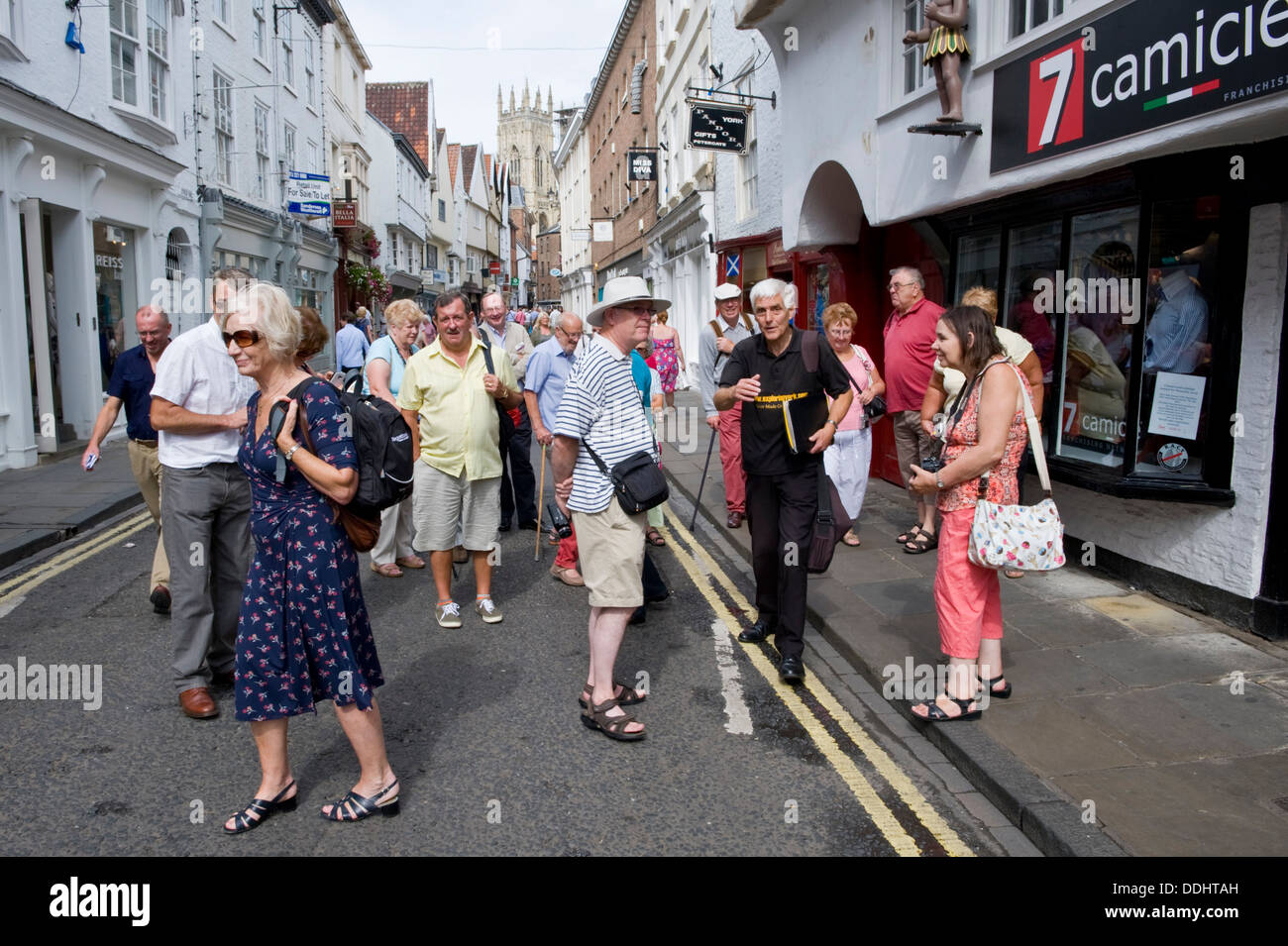 Tourists in official tour group with guide on street in the city of ...