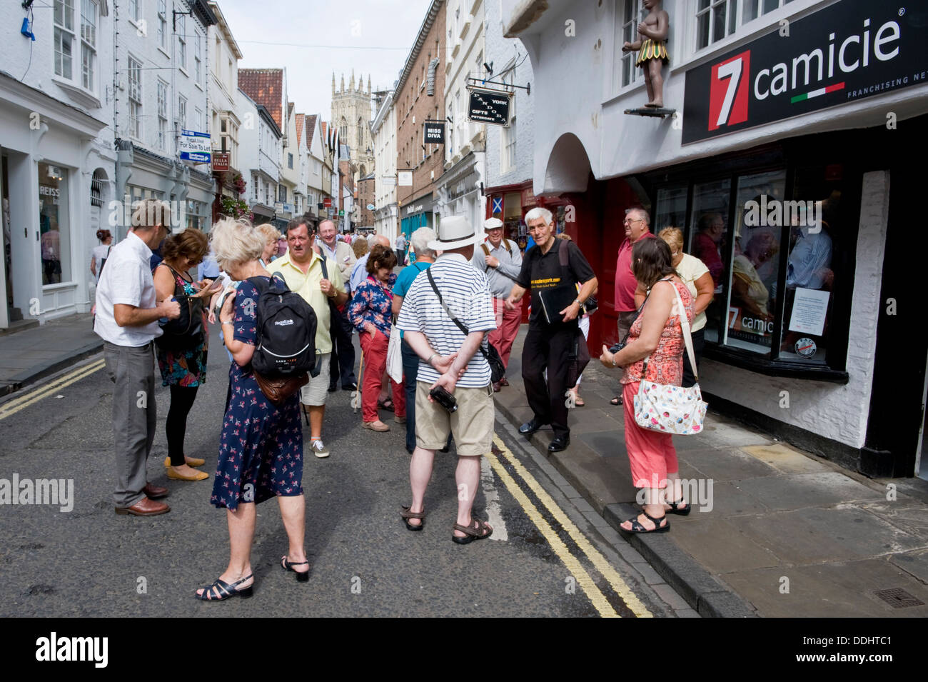 Tourists in official tour group with guide on street in the city of ...