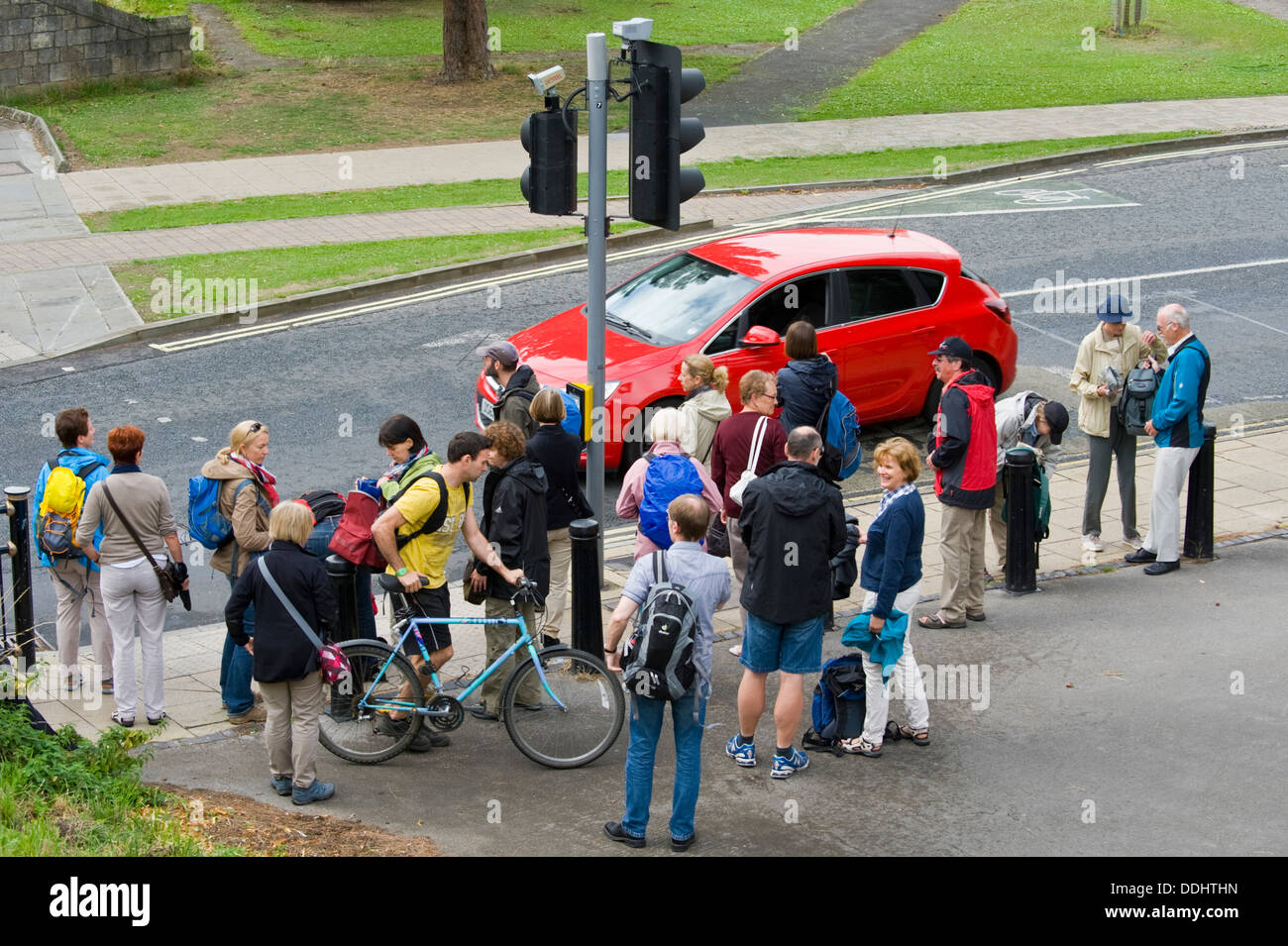 Tourists in official tour group wait to cross road at traffic lights on ...