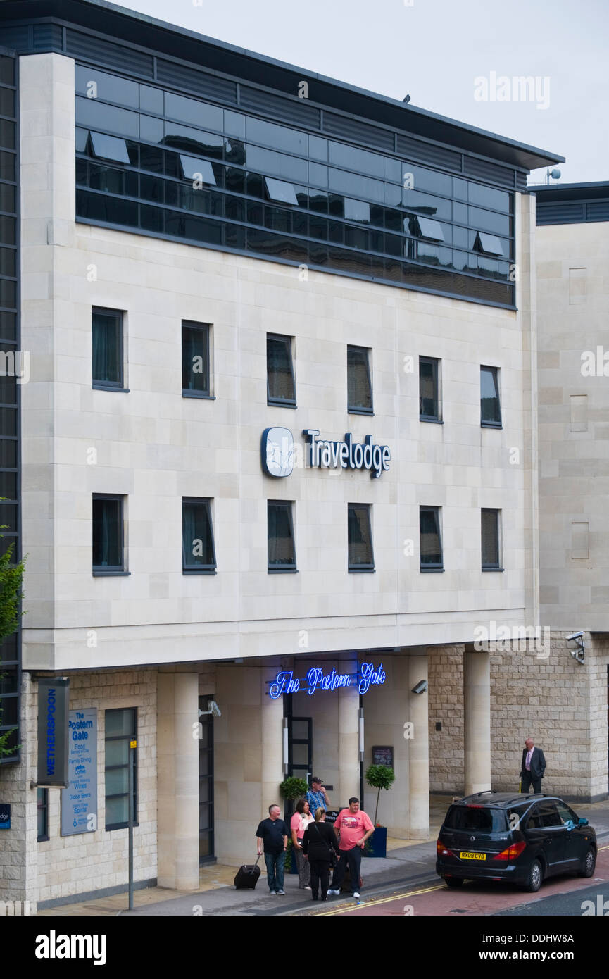 Exterior of TRAVELODGE hotel with people waiting with suitcases for ...