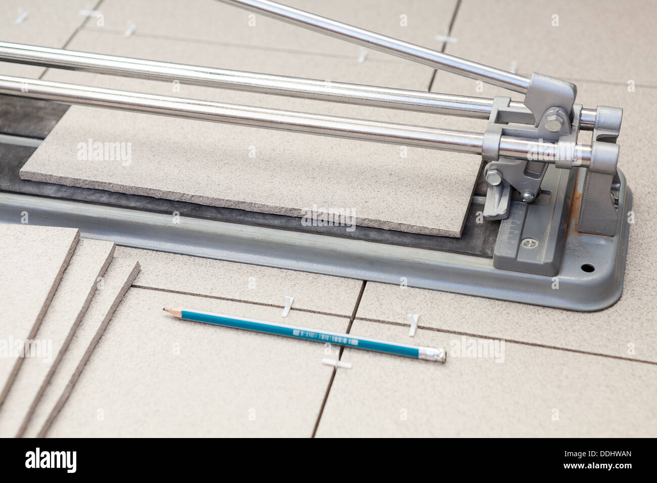 Small tile-cutter with laying tiles and pencil Stock Photo - Alamy