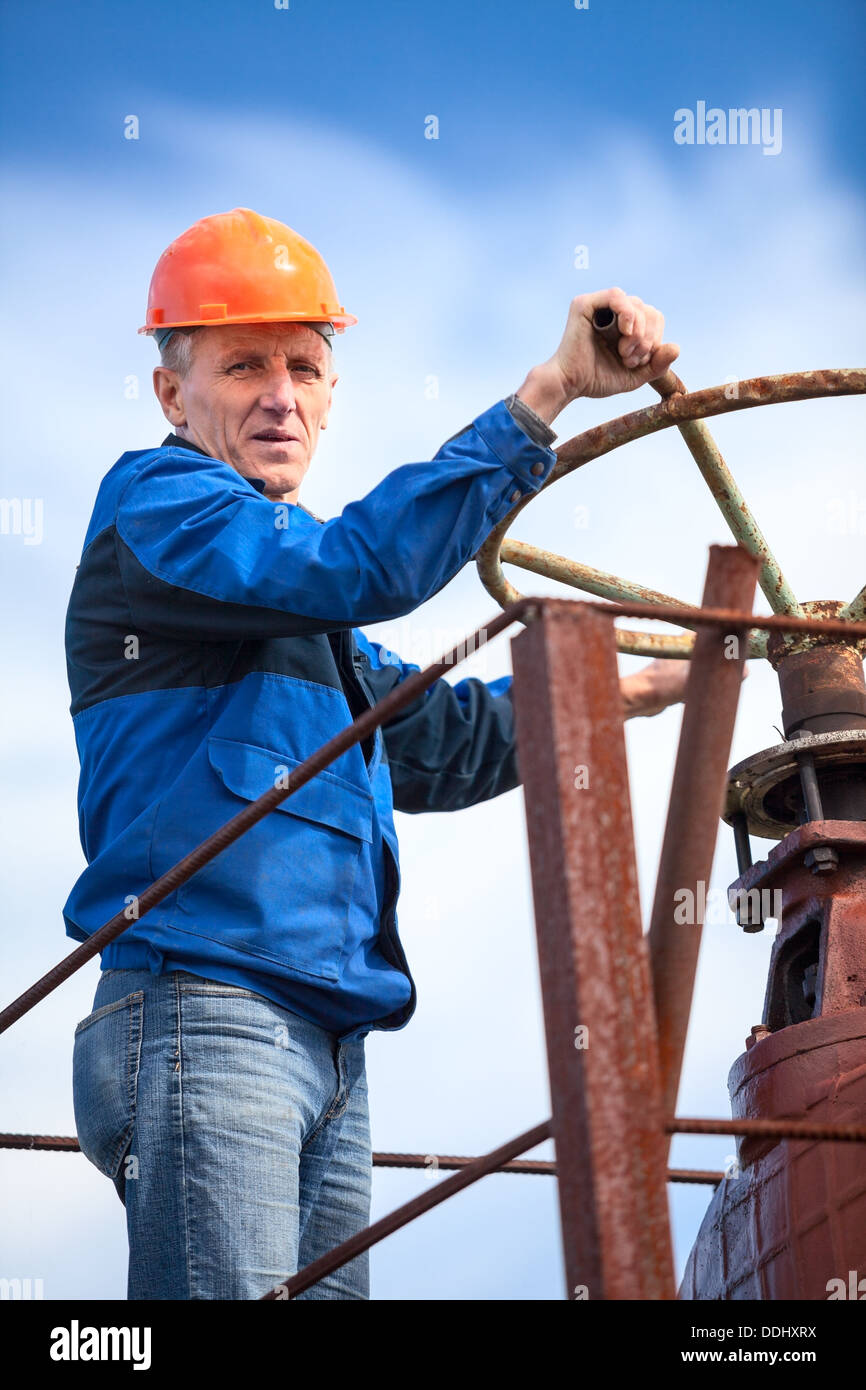 Senior manual worker turning huge valve gate at factory Stock Photo - Alamy
