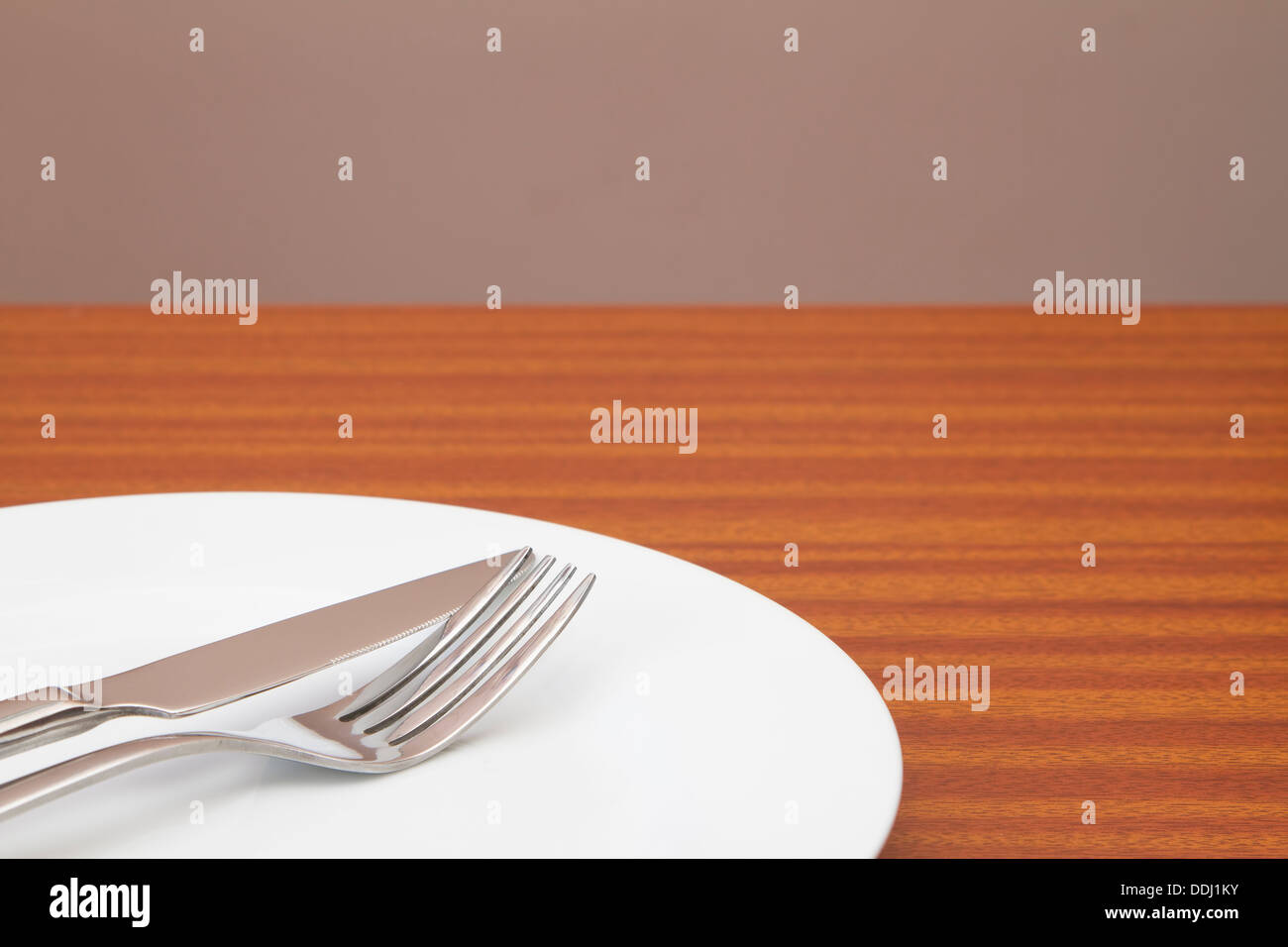 White place setting on wooden table with wall behind Stock Photo - Alamy
