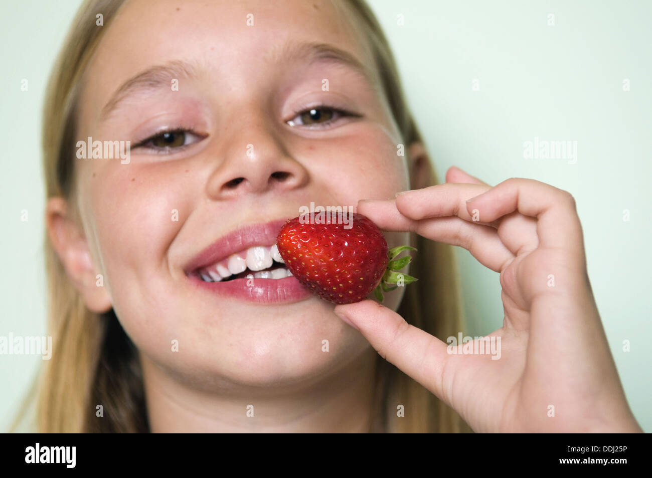 Girl eating strawberries Stock Photo - Alamy