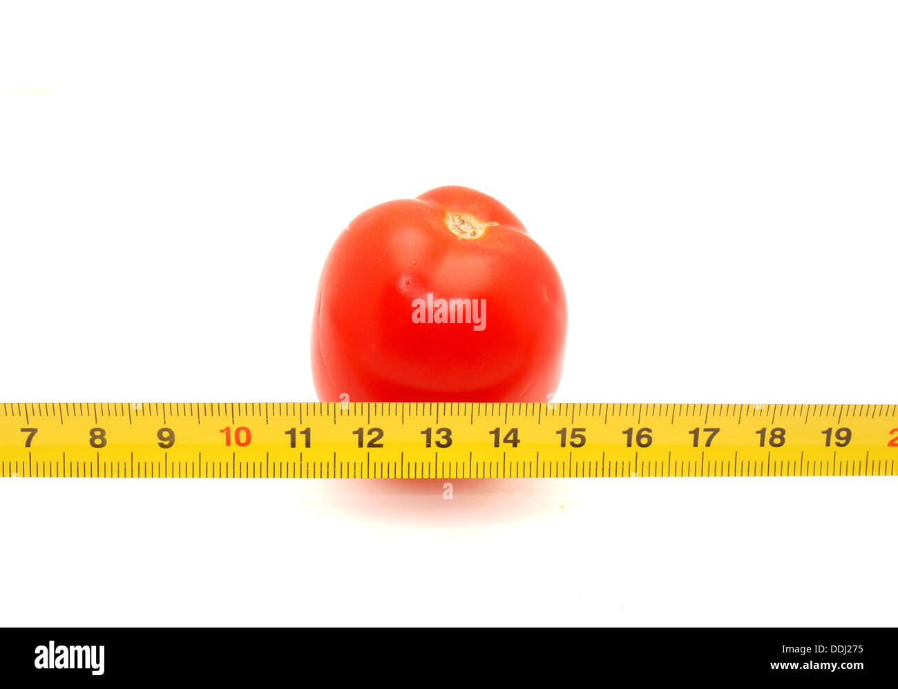Tomatoes and ruler on a white background Stock Photo - Alamy