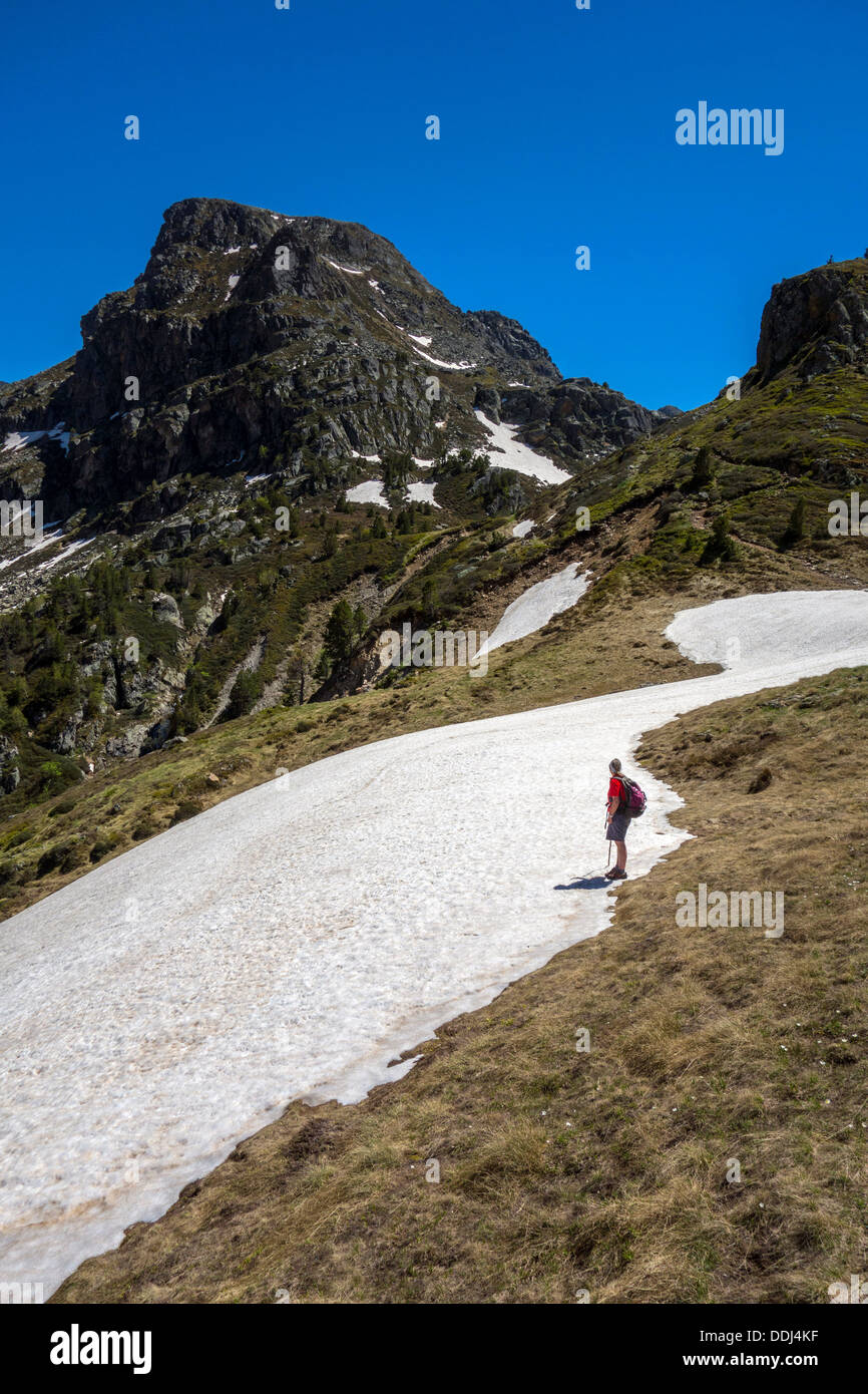 Female walker figure on snow patch, high summer, French Pyrenees ...