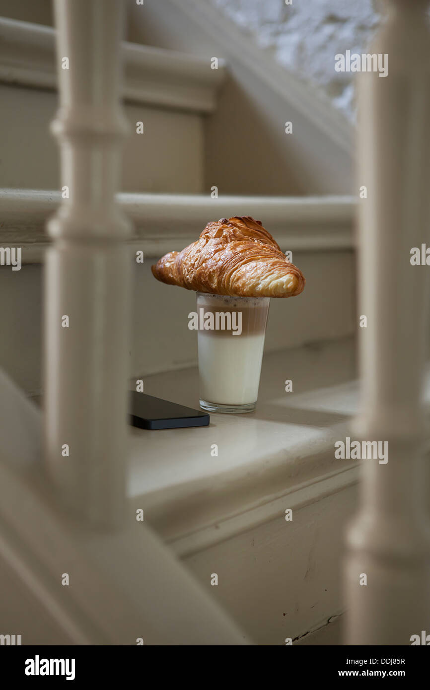 Croissant and drink on steps with mobile phone Stock Photo - Alamy