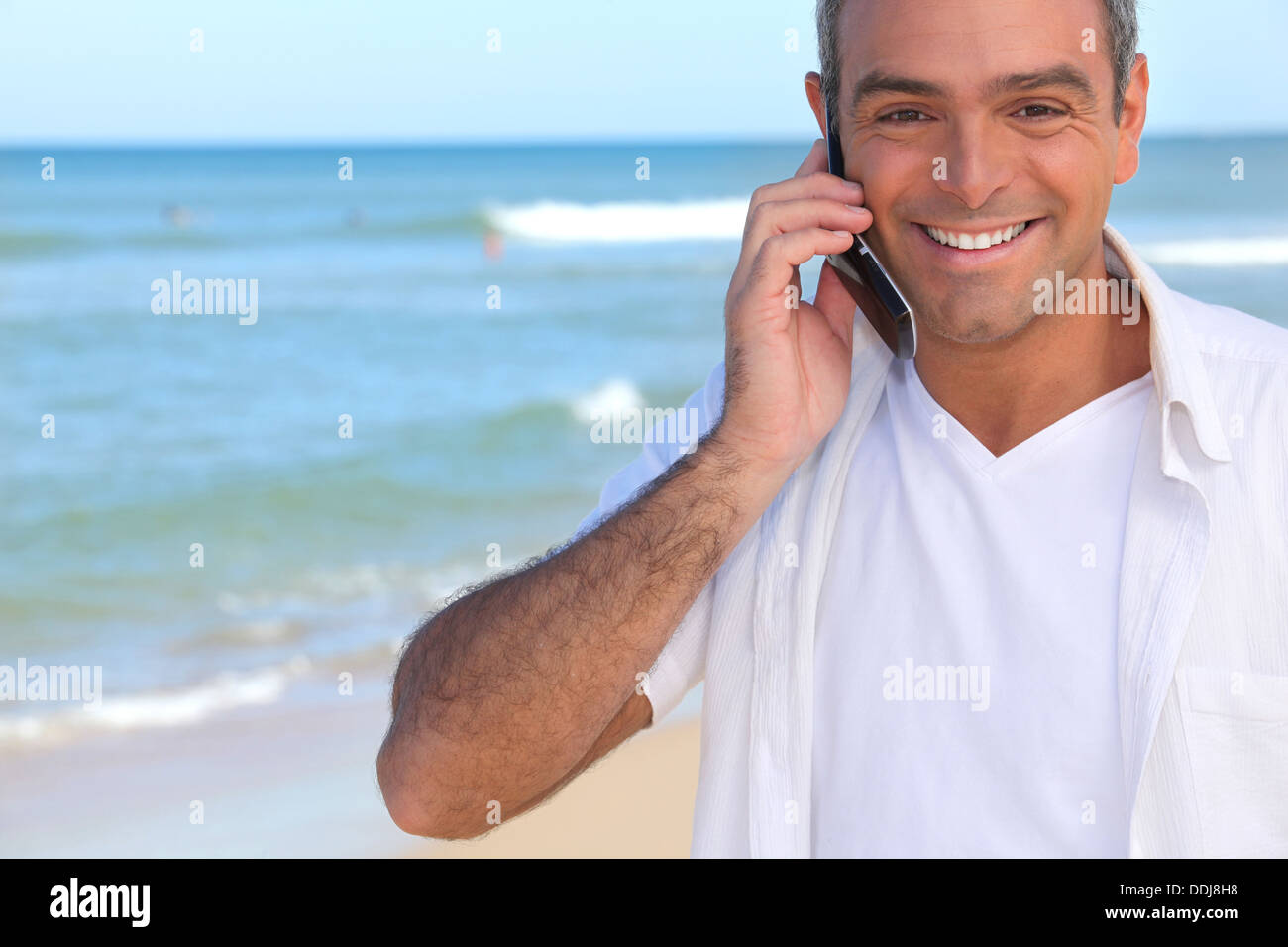 Man taking a call whilst at the beach Stock Photo - Alamy