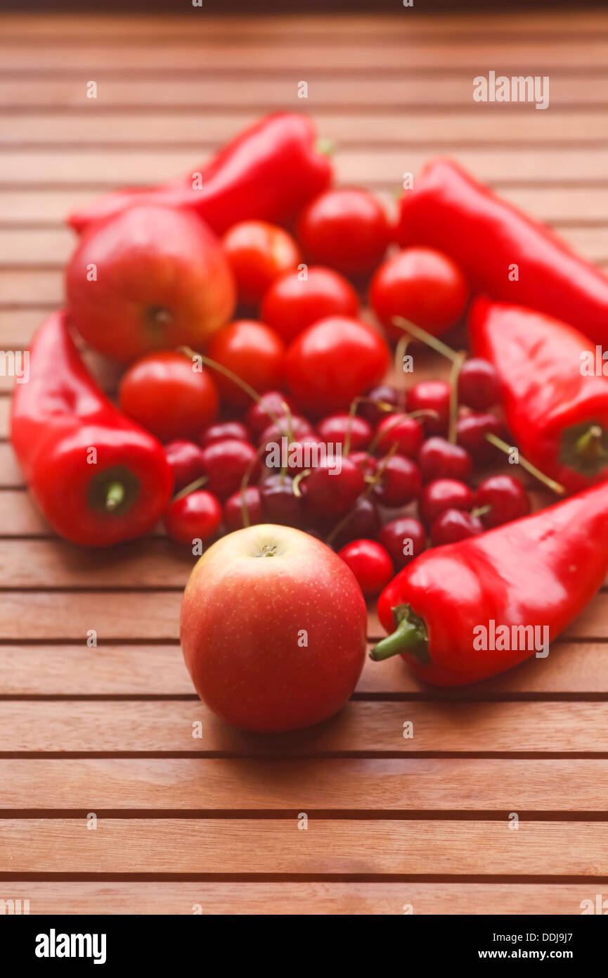 Germany, Varieties of fruits with red pointed pepper on wooden table ...