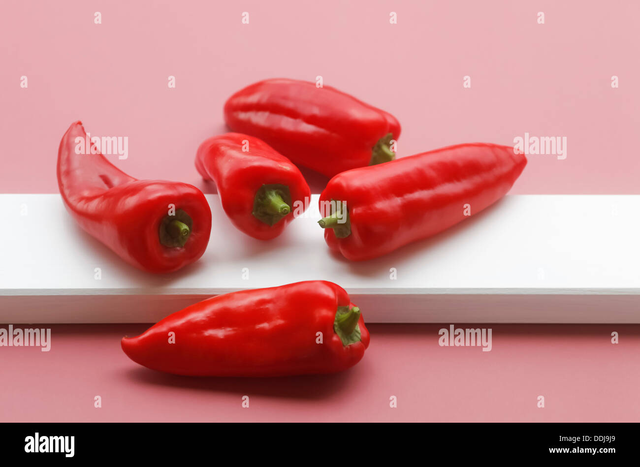Red pointed pepper on pink background, close up Stock Photo - Alamy