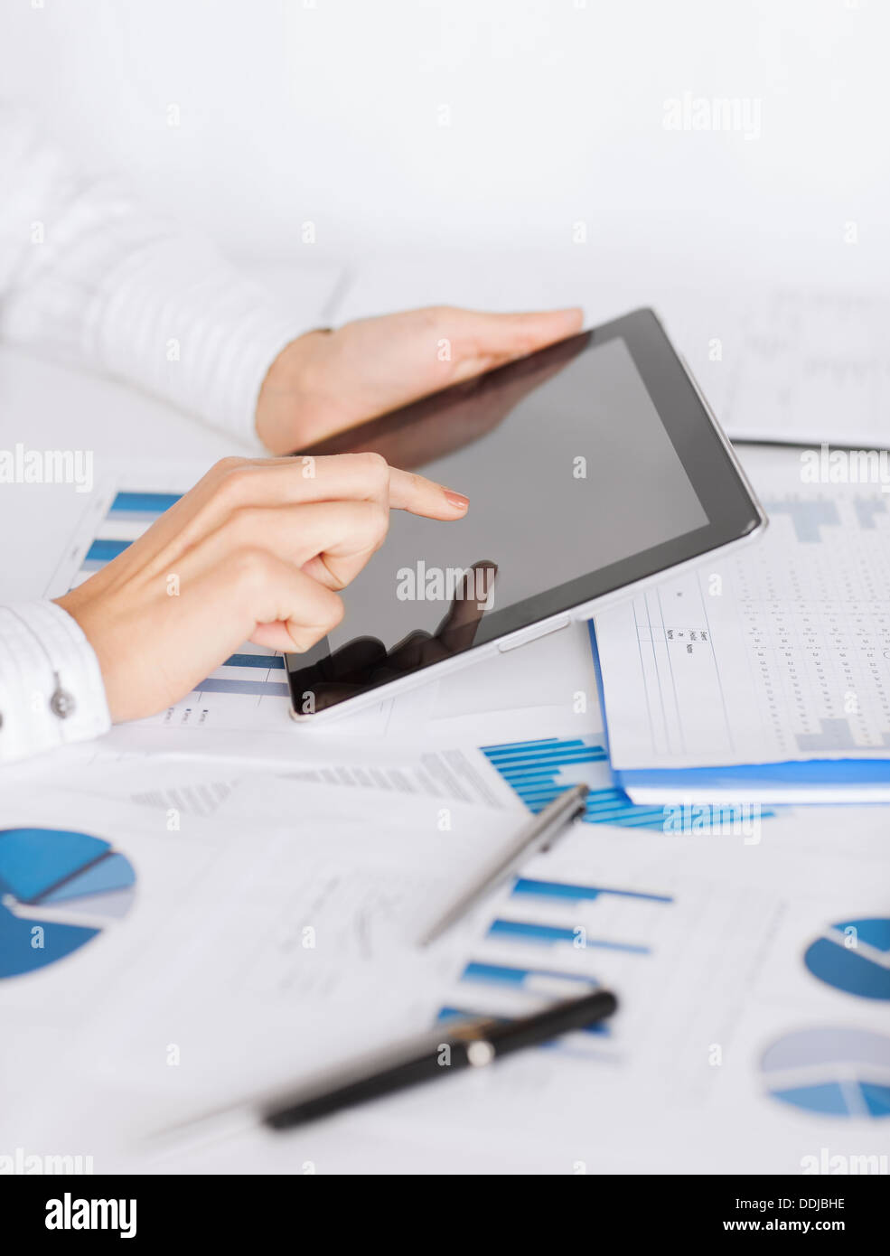 woman with tablet pc and chart papers Stock Photo - Alamy