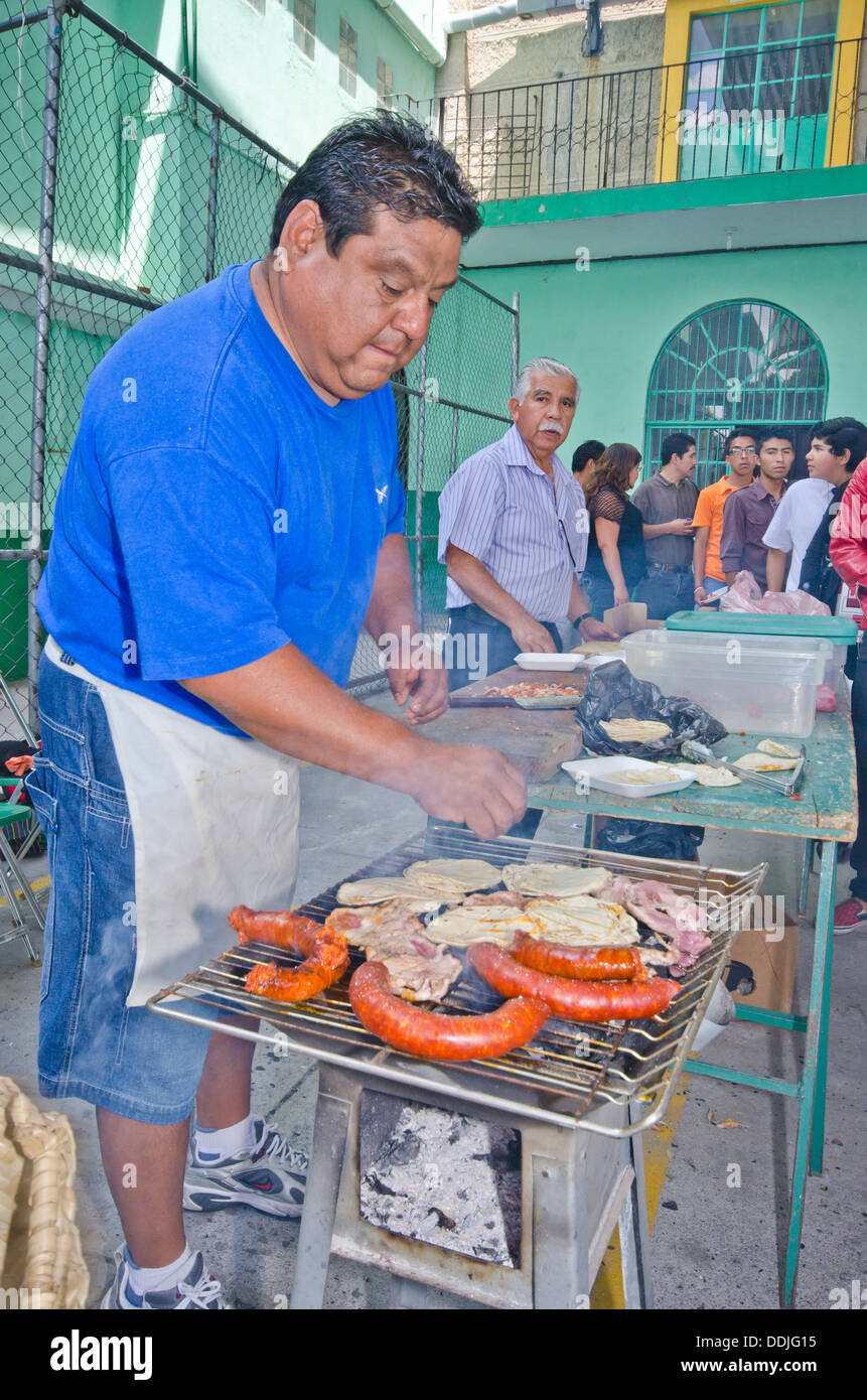 Man barbeques long Mexican chorizo sausages (longaniza) and meat at ...